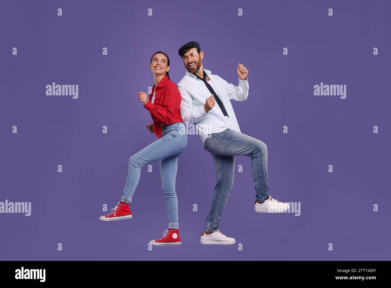 Happy couple dancing together on violet background Stock Photo - Alamy
