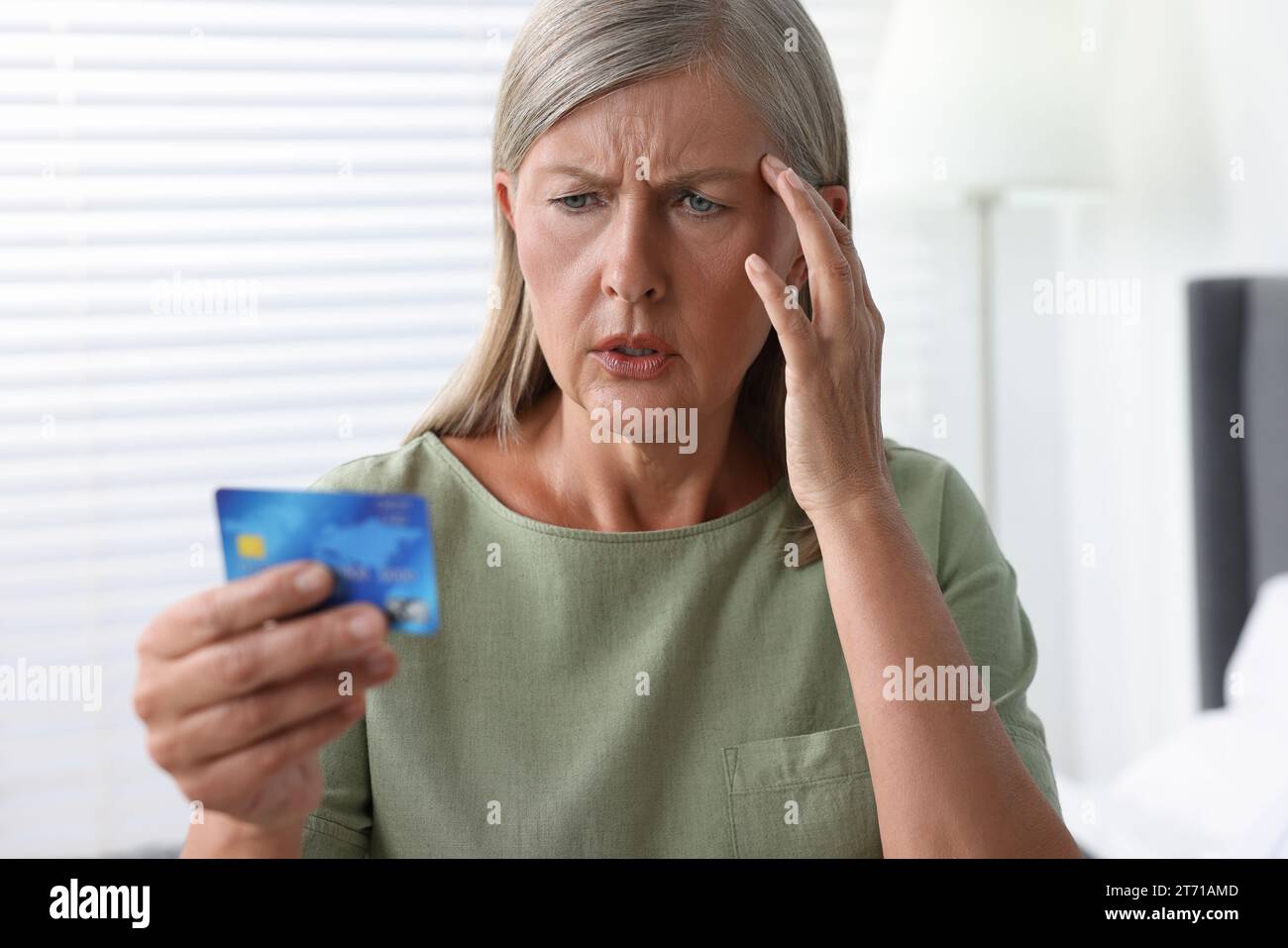 Scammed woman with credit card indoors. Be careful - fraud Stock Photo ...