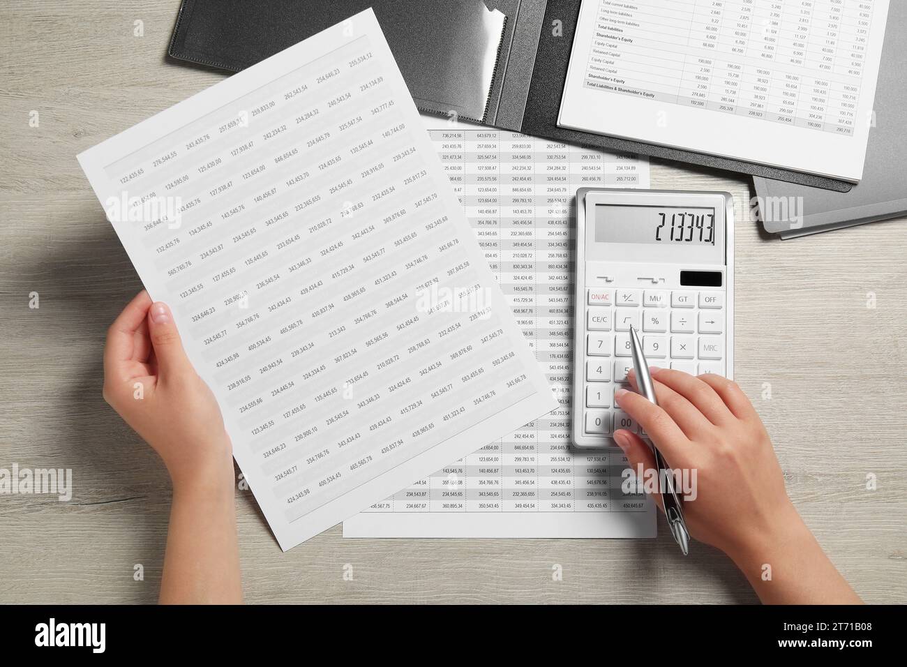Woman making calculations on calculator at wooden table, top view Stock ...
