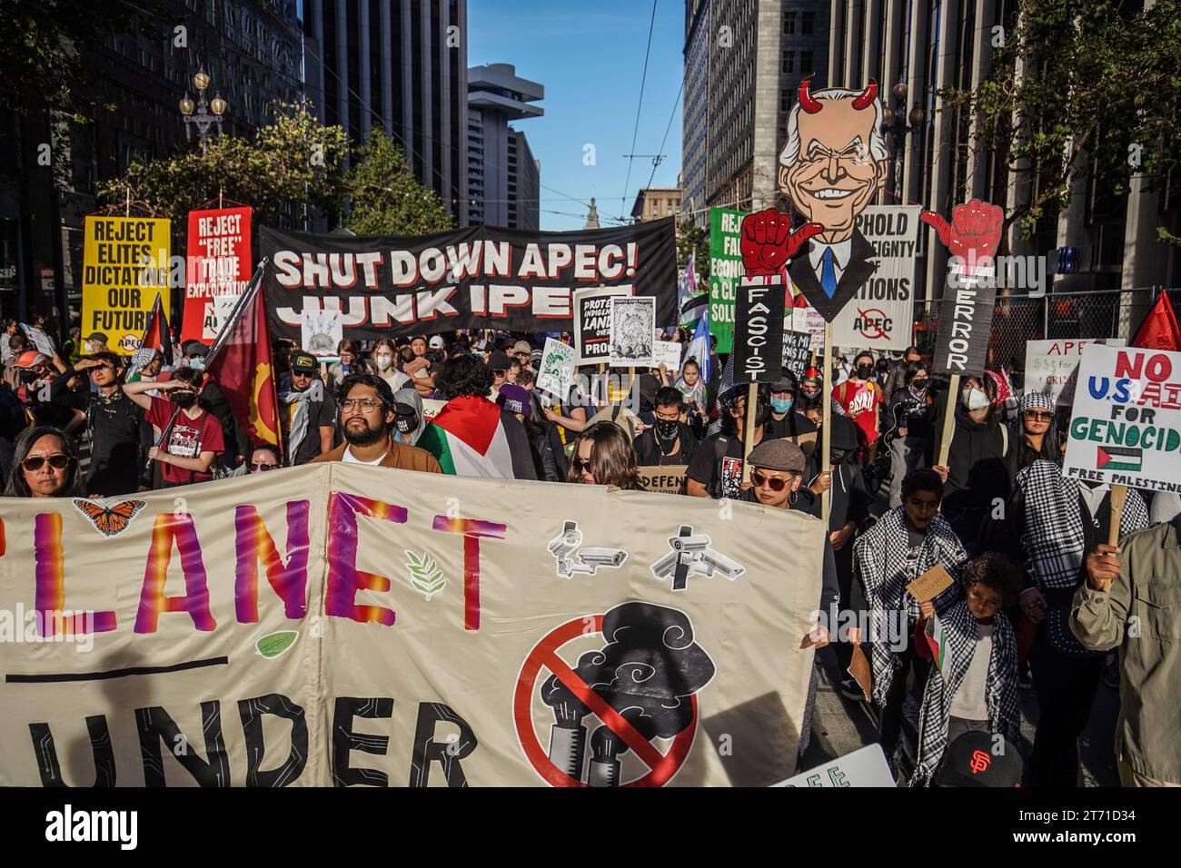 People hold banners, placards and flags while they march on the street ...