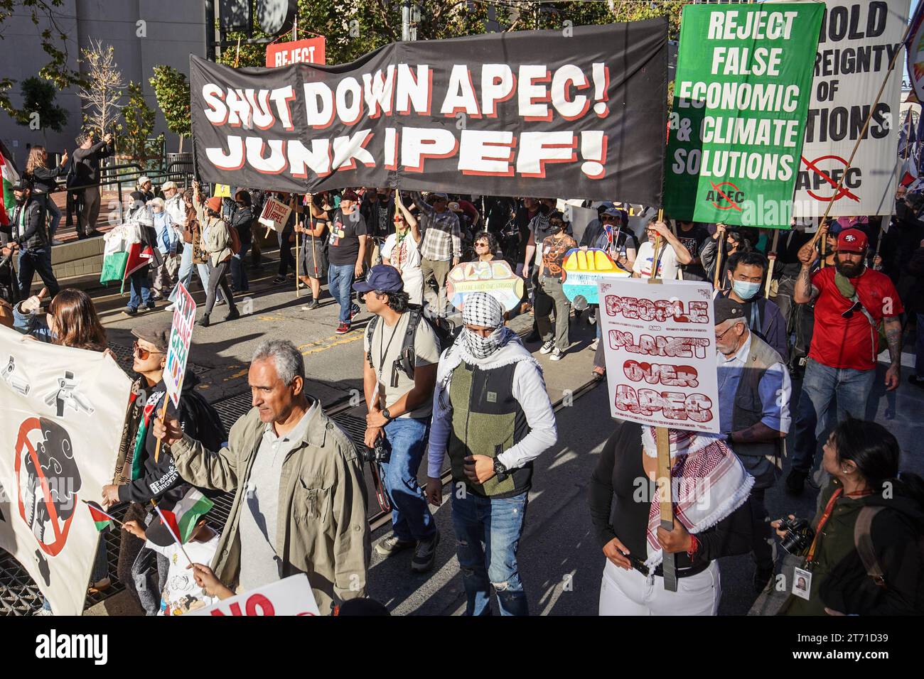 People hold banners, placards and flags while they march on the street ...