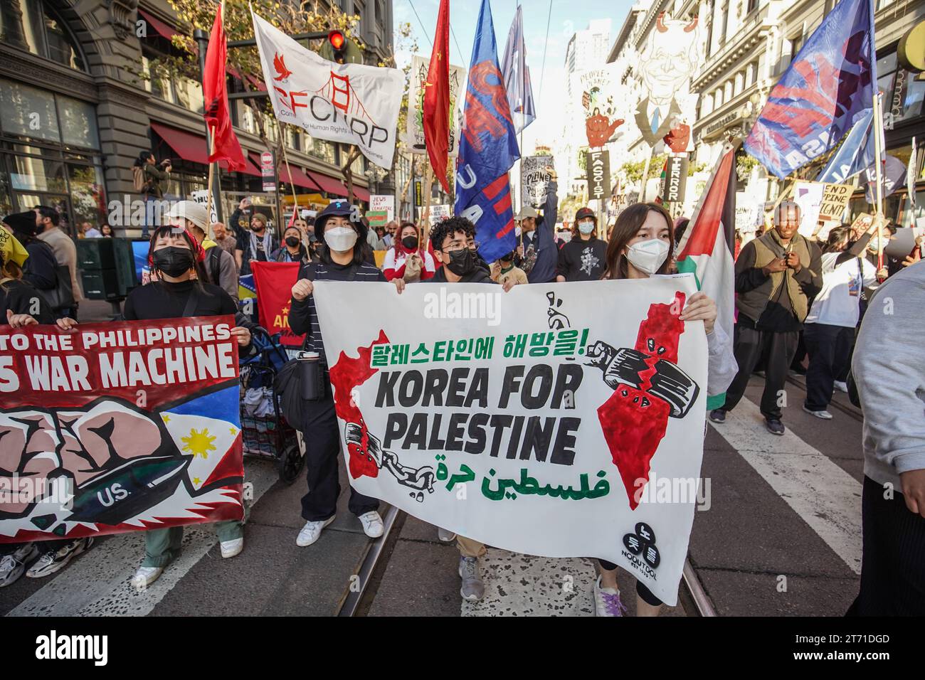 People hold banners and flags while they march on the street. The Asia ...