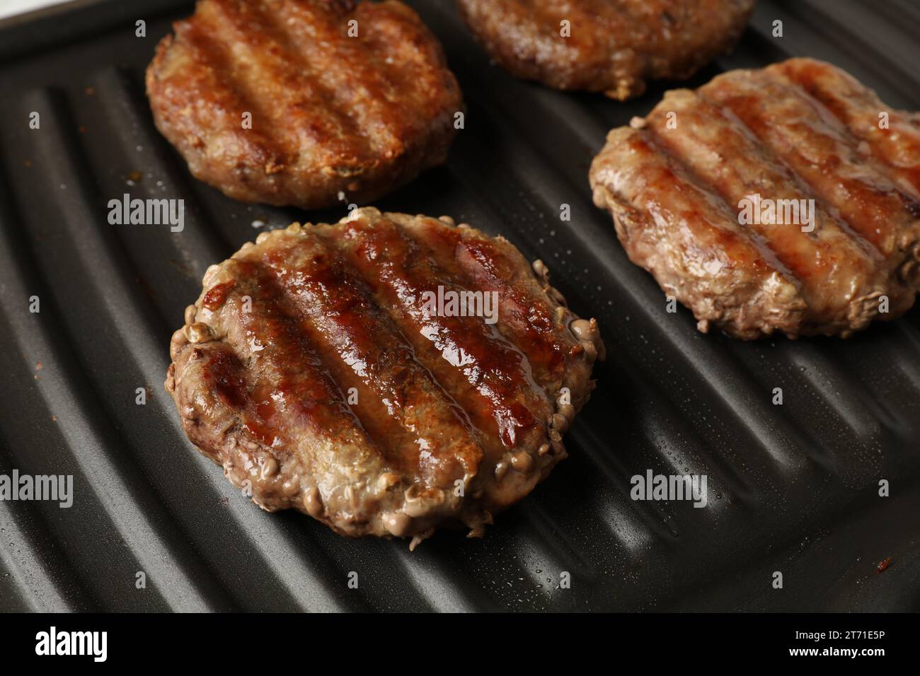 Delicious hamburger patties cooking on electric grill, closeup Stock ...