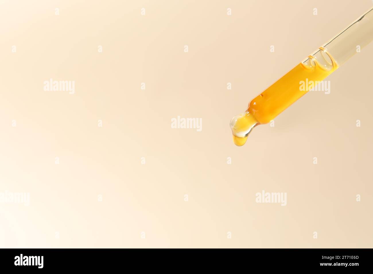 Dripping cosmetic serum from pipette on beige background, closeup ...