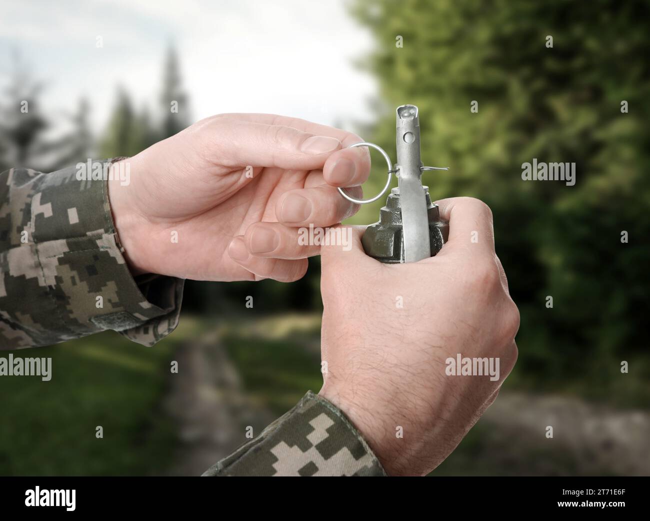 Soldier pulling safety pin out of hand grenade in forest, closeup Stock ...