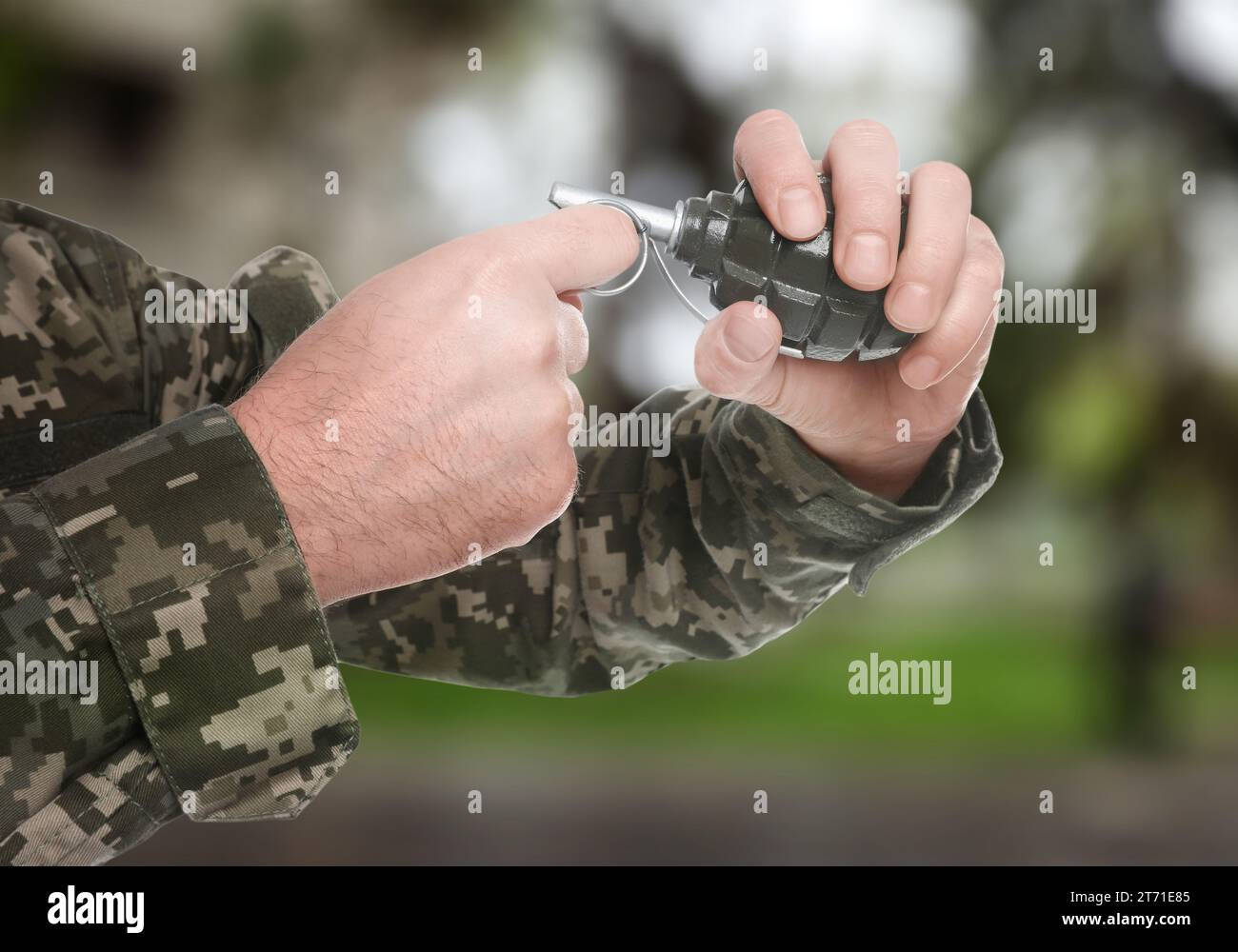 Soldier pulling safety pin out of hand grenade outdoors, closeup Stock ...