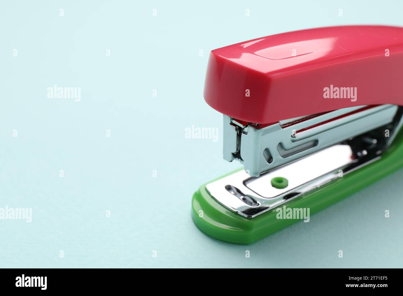 One bright stapler on light blue background, closeup. Space for text ...