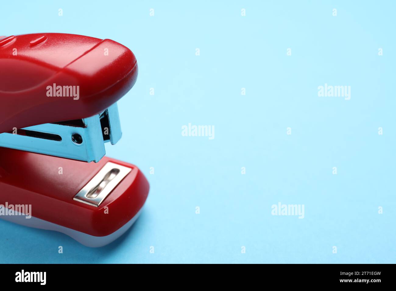 One red stapler on light blue background, closeup. Space for text Stock ...