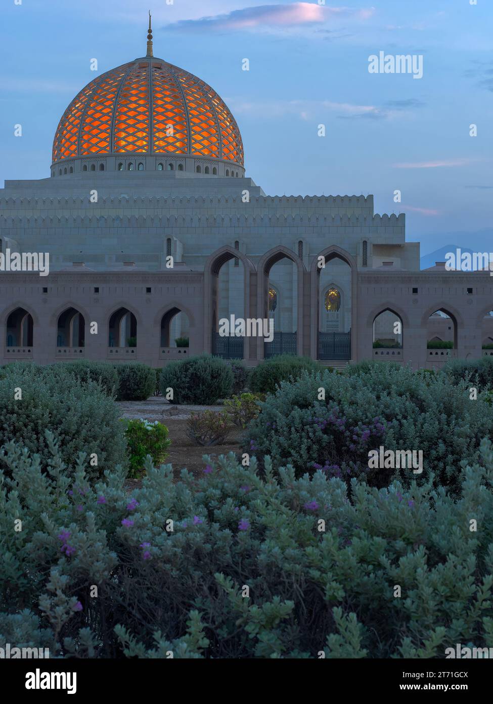 The dome of Sultan Qaboos Grand Mosque illuminated against a beautiful ...