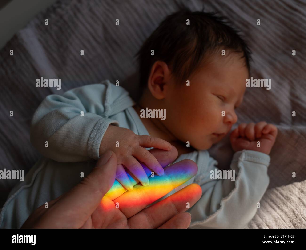 A man holds his newborn son's hand. Beam of light through a prism Stock ...
