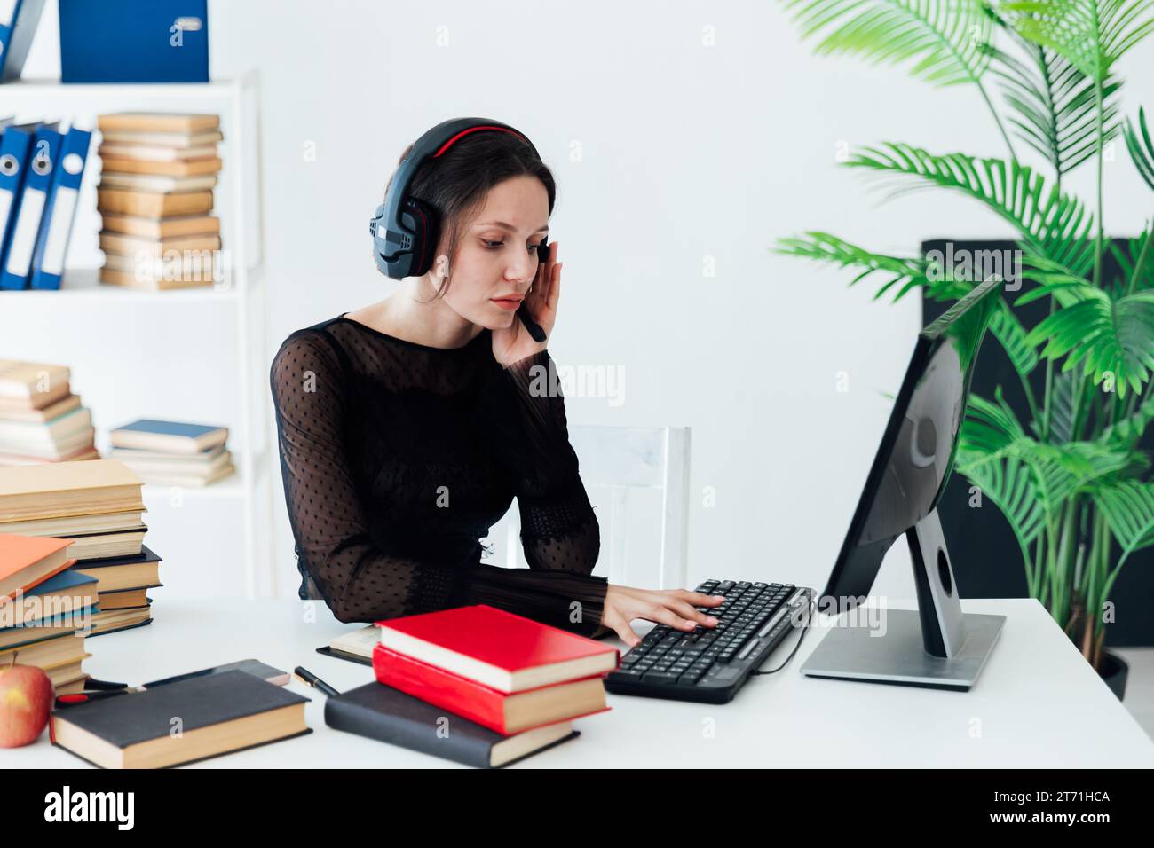 business woman office worker in headphones in the office at a desk with ...