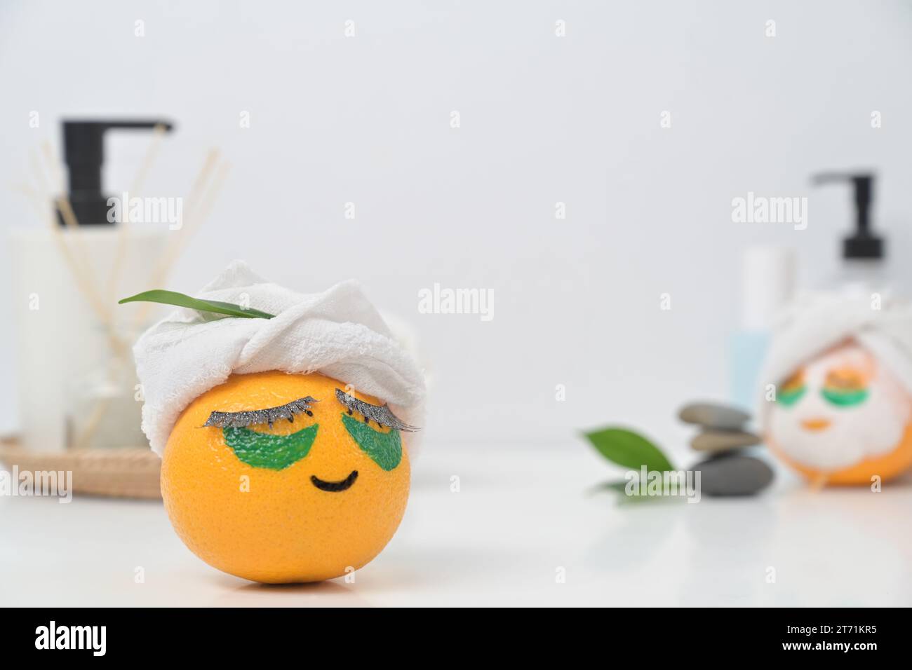 An orange fruit with towel and patches under eyes. Spa treatment and ...