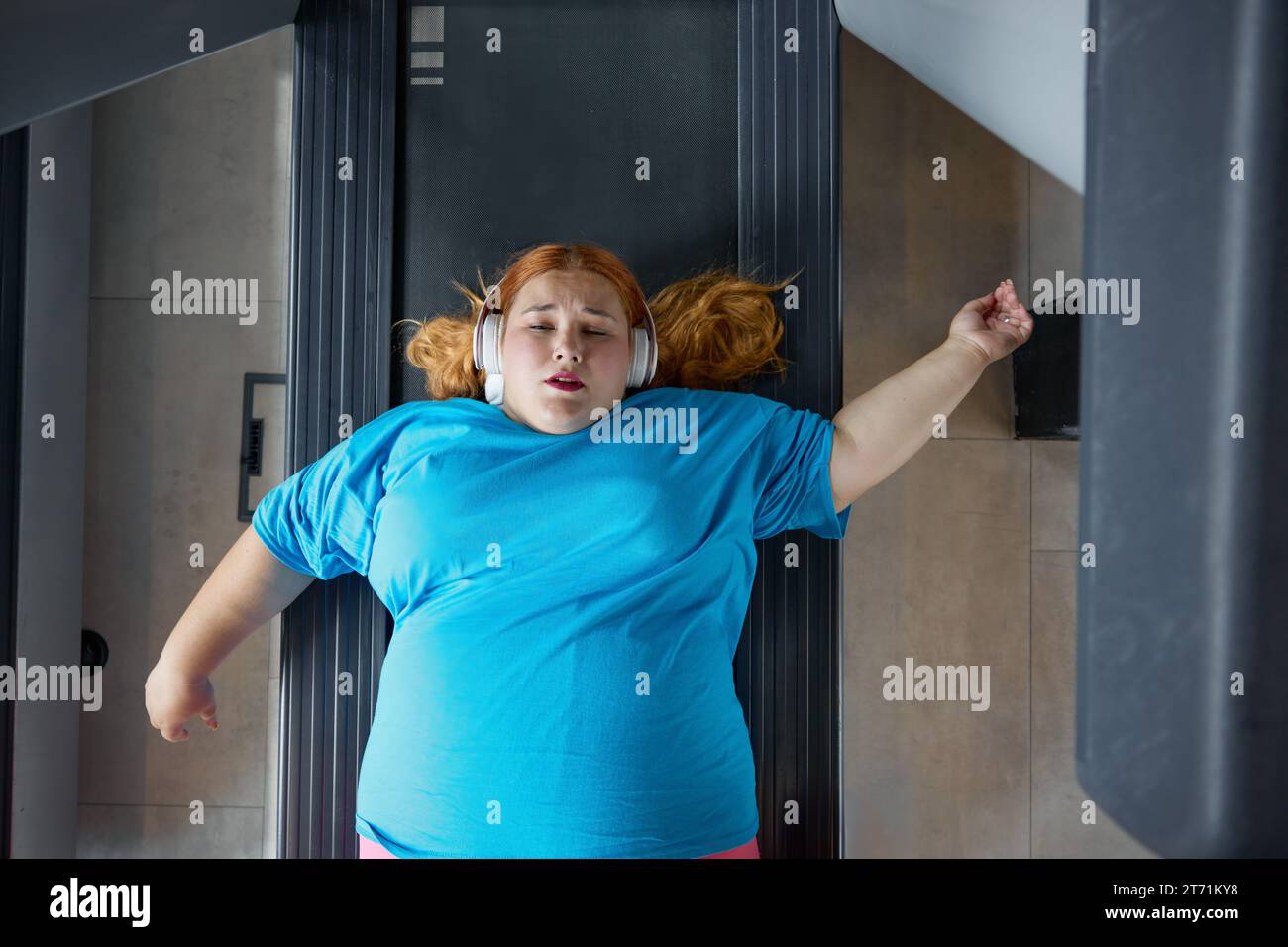 Sad unhappy overweight woman feeling pain while training at wall for ...