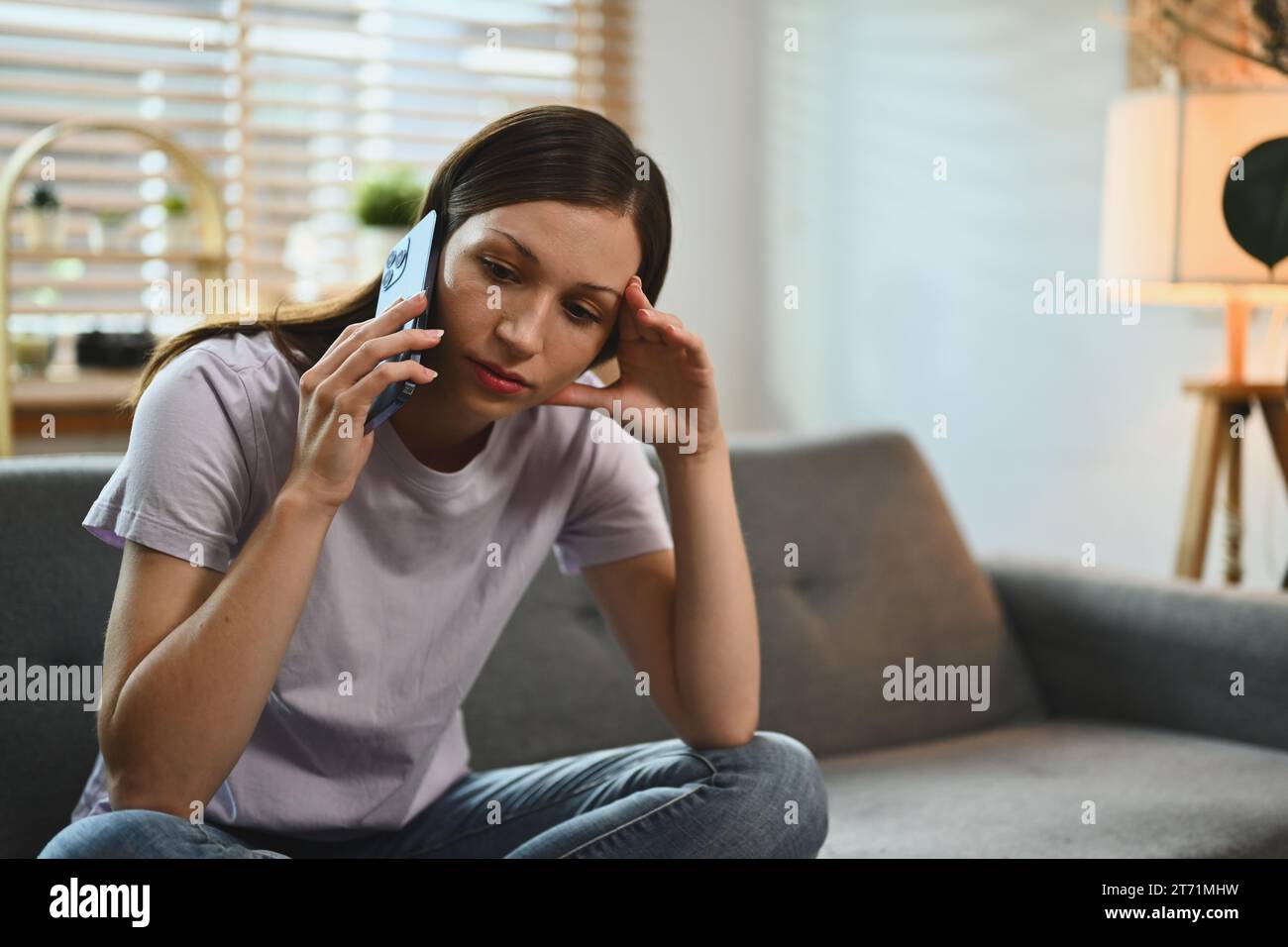 Worried young woman having unpleasant phone conversation receiving bad ...