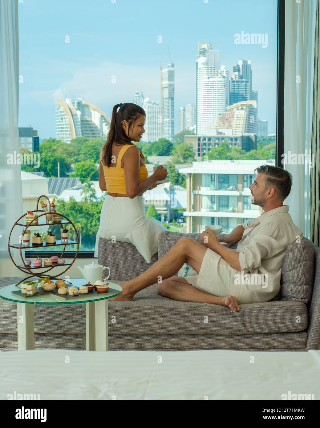 A couple of men and woman having afternoon tea or high tea in a hotel ...