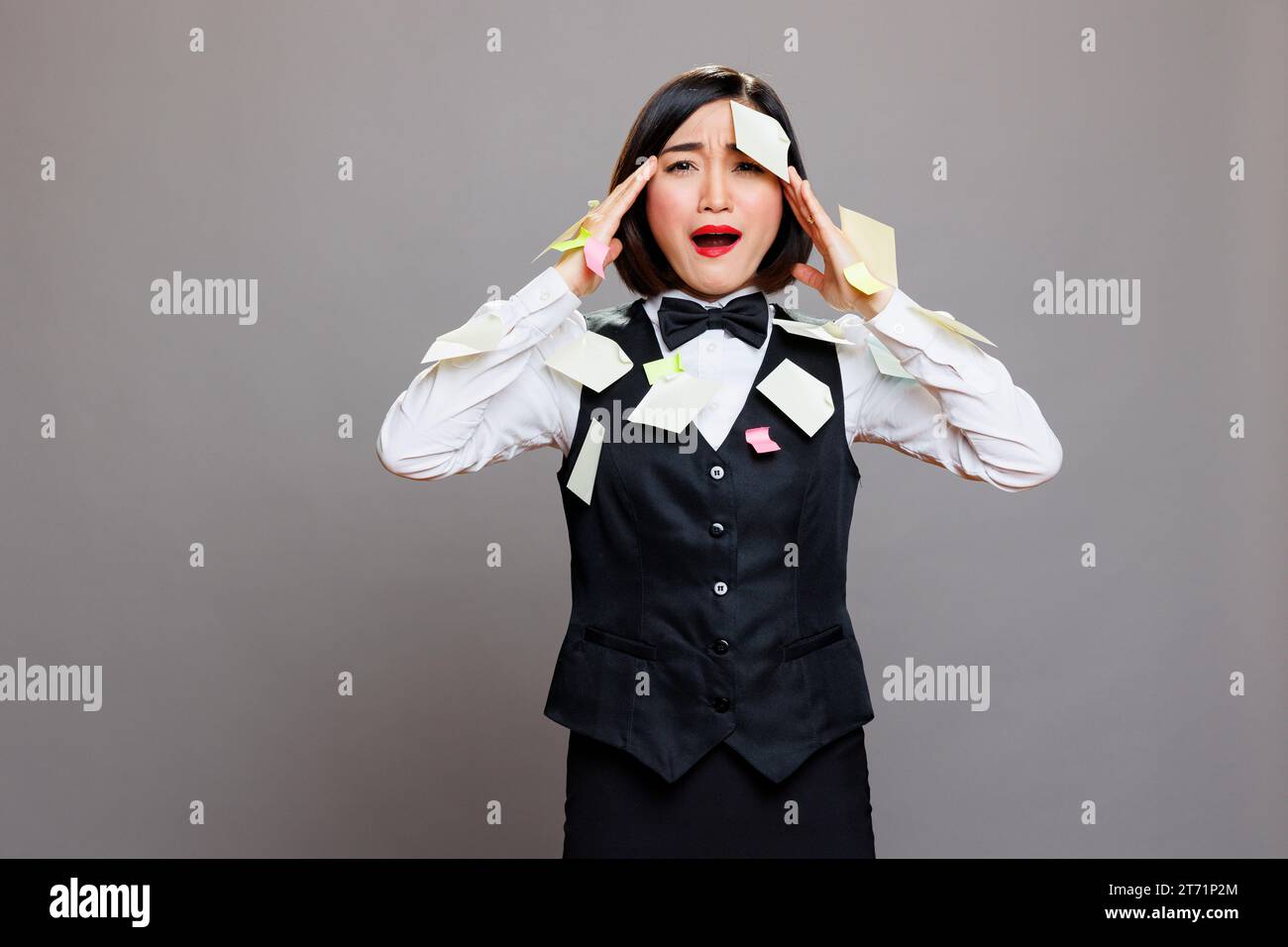 Stressed asian waitress overloaded with tasks sticky notes holding ...