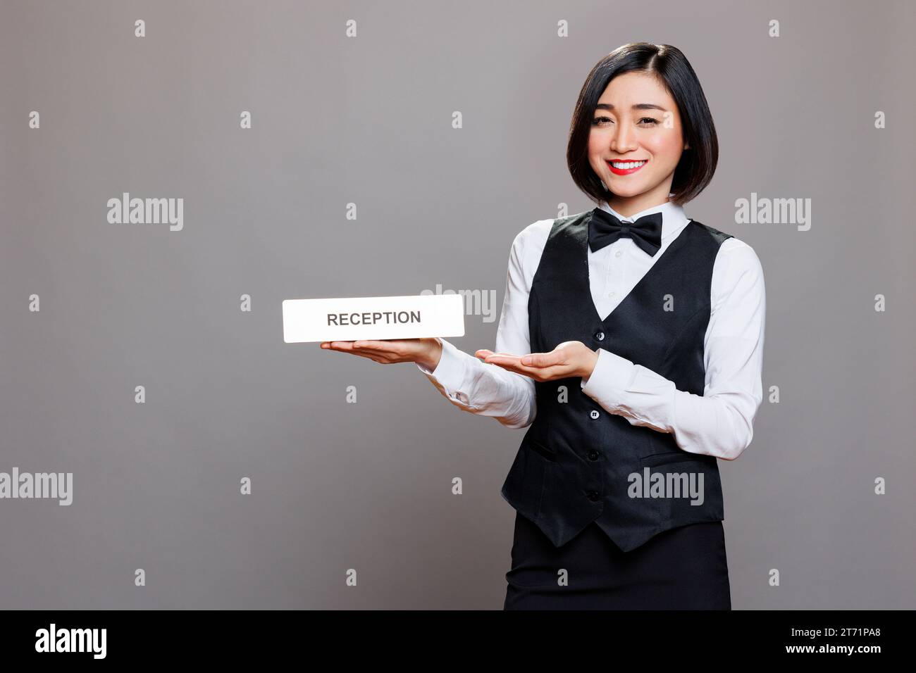 Restaurant receptionist showcasing reception steel plate, smiling and ...