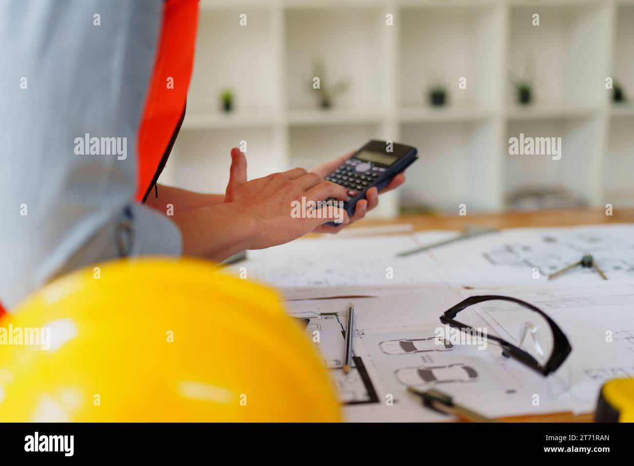 engineers discuss building on blueprint drawing using calculator Stock ...