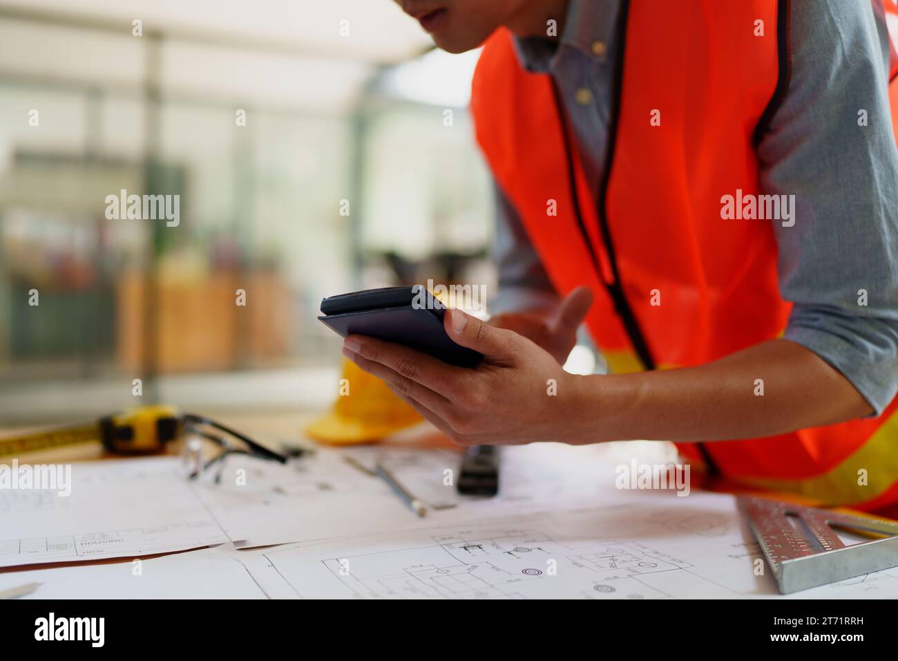 engineers discuss building on blueprint drawing using calculator Stock ...
