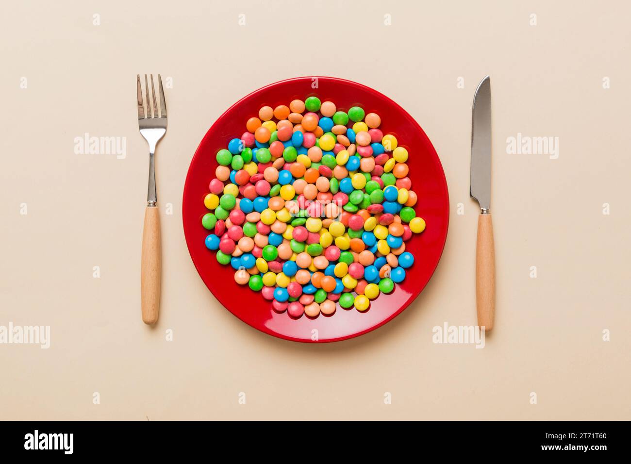cutlery on table and sweet plate of candy. Health and obesity concept ...
