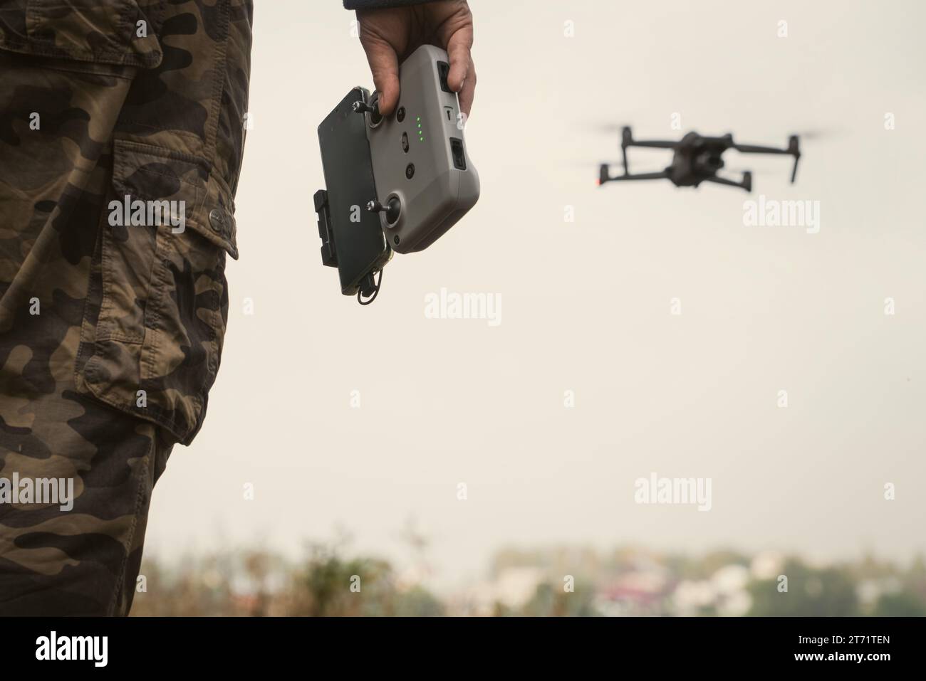 a man in a military uniform with a UAV control panel in his hands, a ...