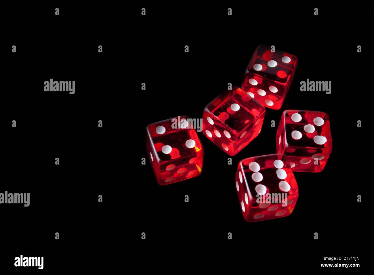 5 red dice in a corner on black background; 5 red dice in a corner on ...