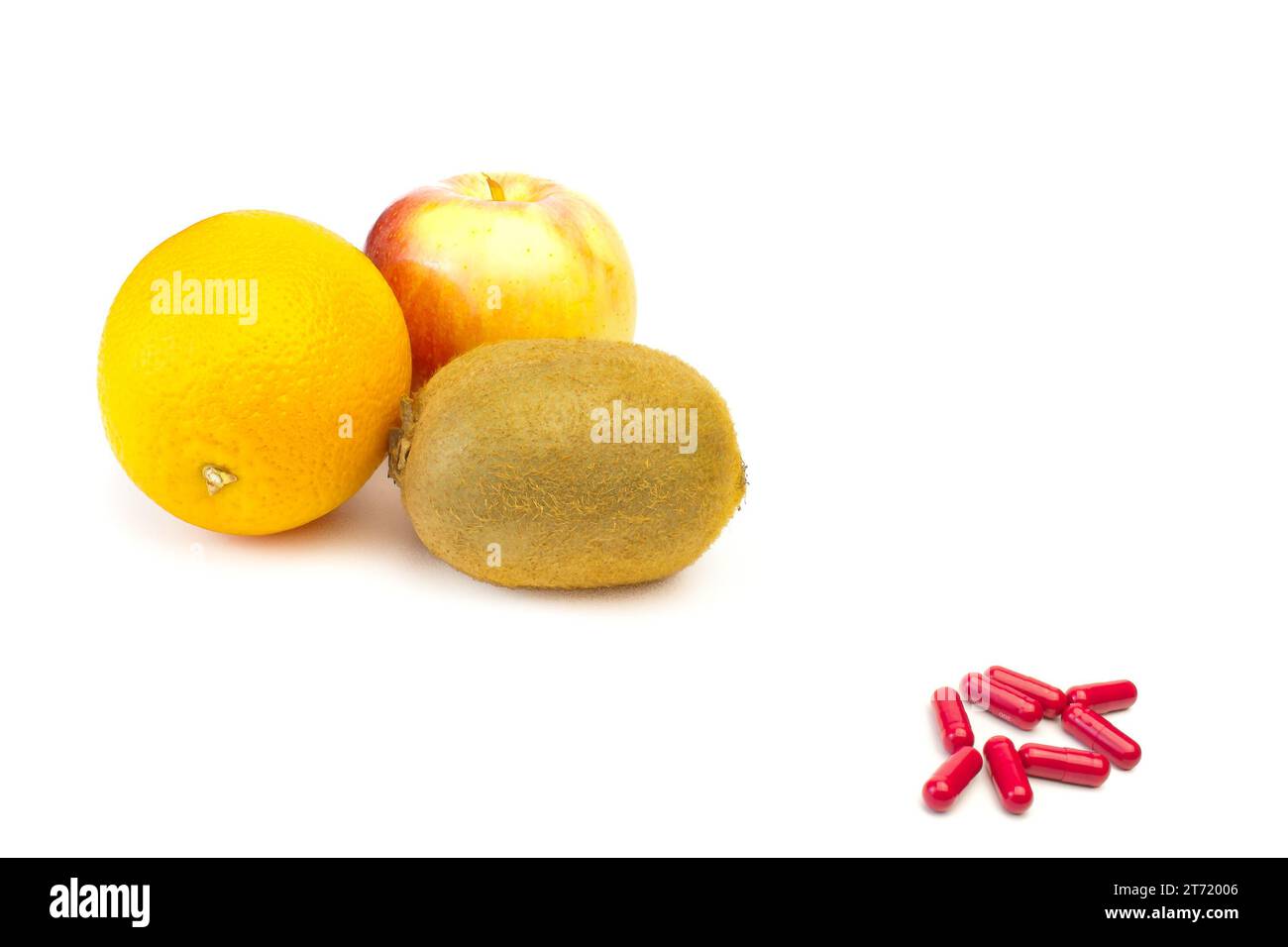 detail of fruit and red pills on white background; detail of fruit and ...