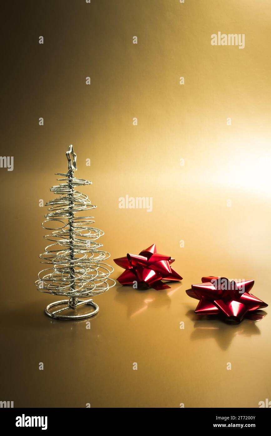detail of silver christmas tree with red bows on gold background ...