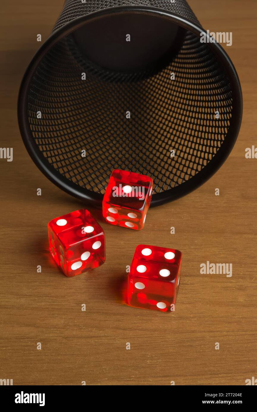 red dice near a container on old wood table Stock Photo - Alamy