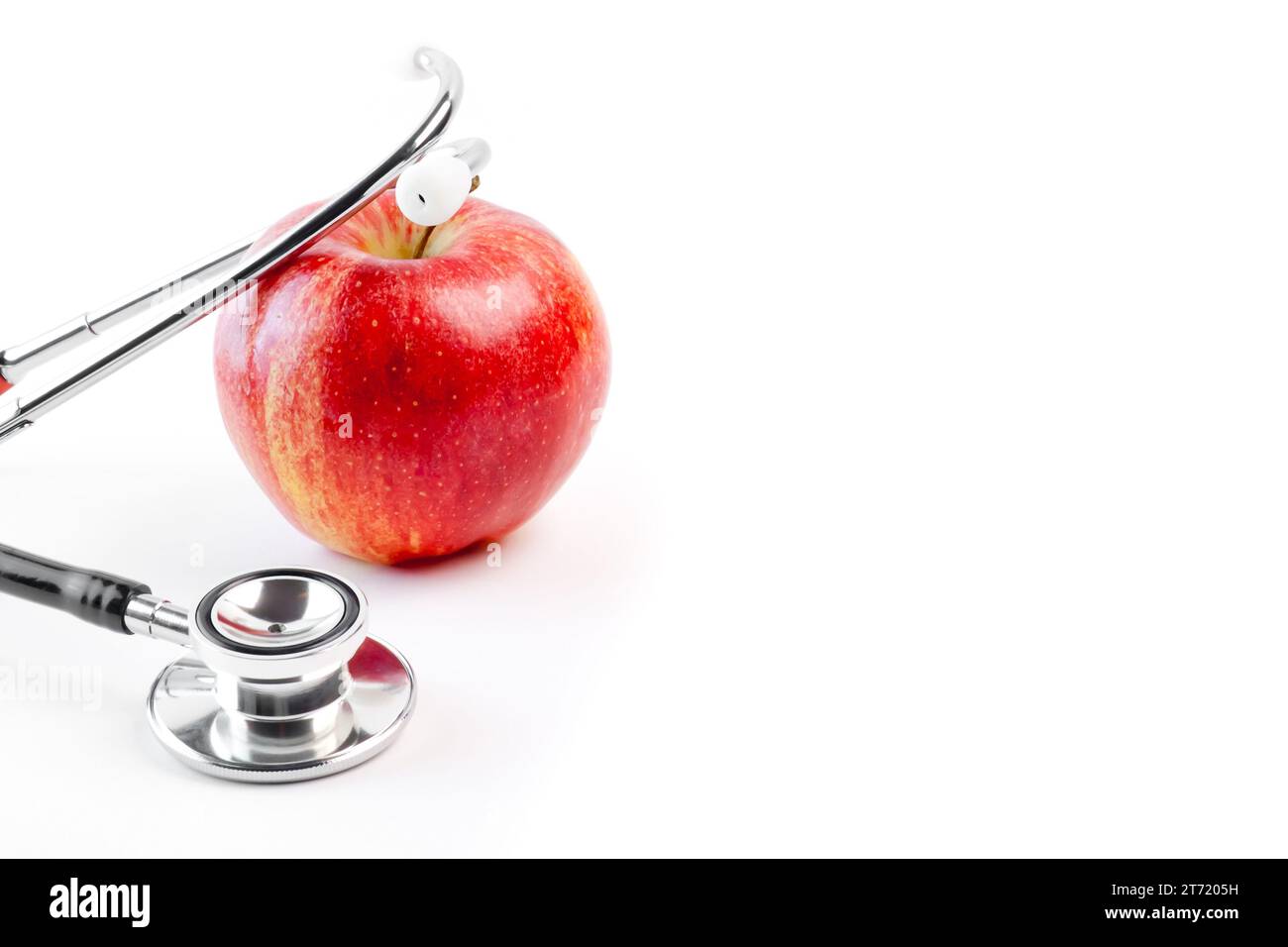 detail of medical stethoscope on red apple on a white background with ...
