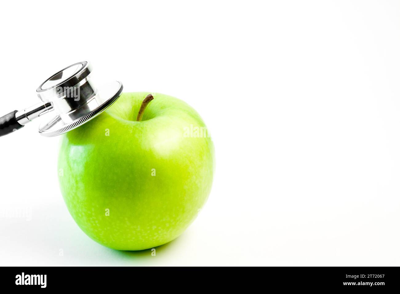detail of medical stethoscope and apple on a white background with ...