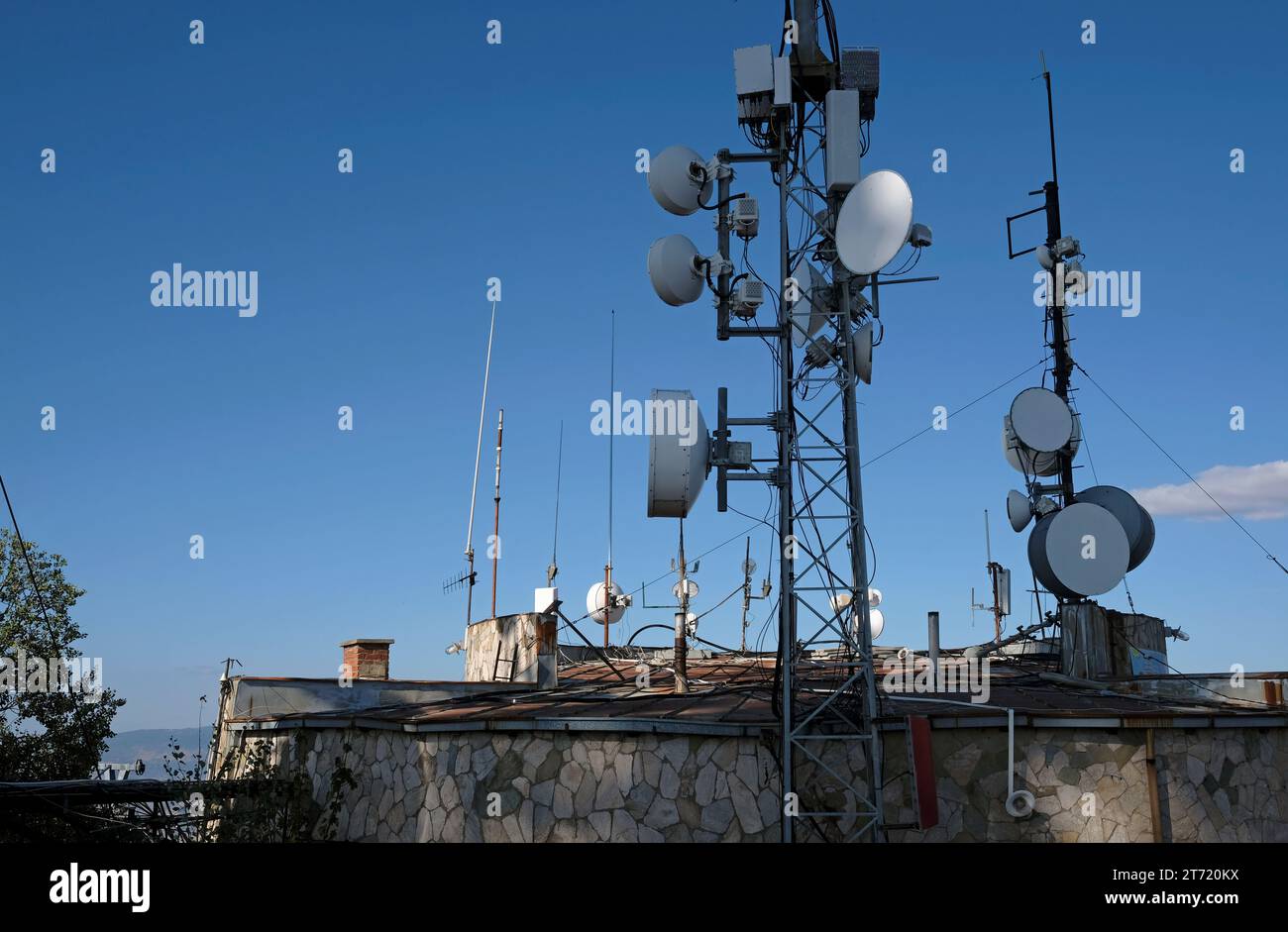 Telecommunication antenna with multiple satellite dishes against the ...