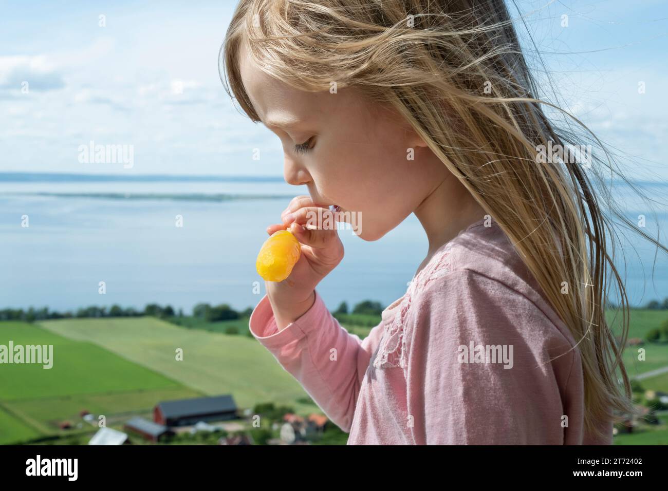 Girl eating ice pop by sea Stock Photo - Alamy