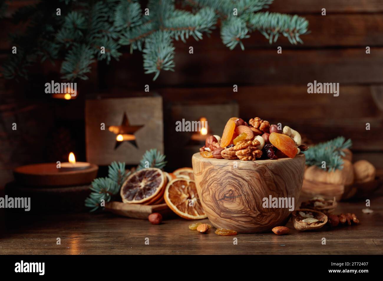 Dried fruits and assorted nuts on an old wooden table. Christmas still ...
