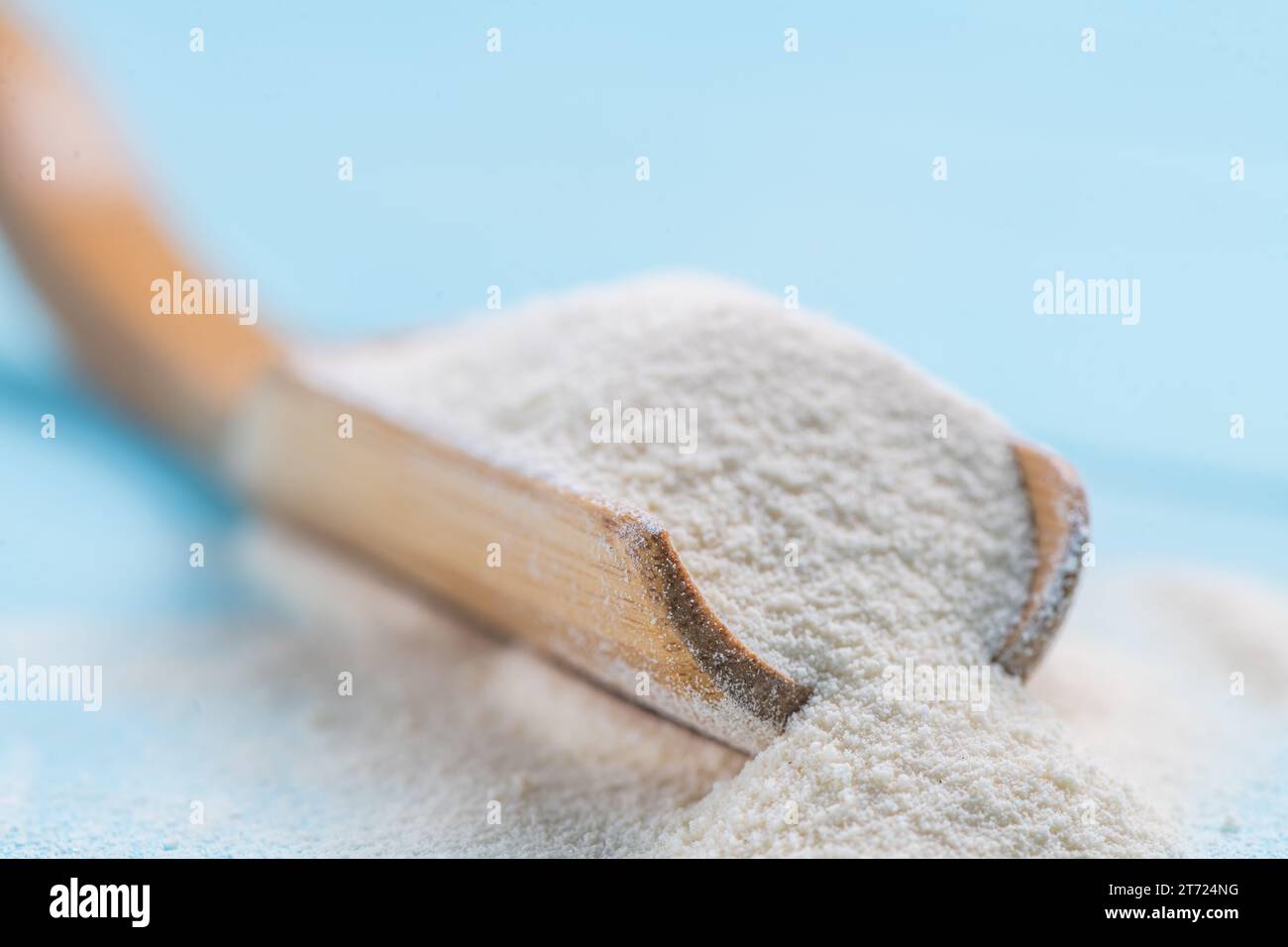 Collagen powder in spoon on wooden blue background close up. Extra ...