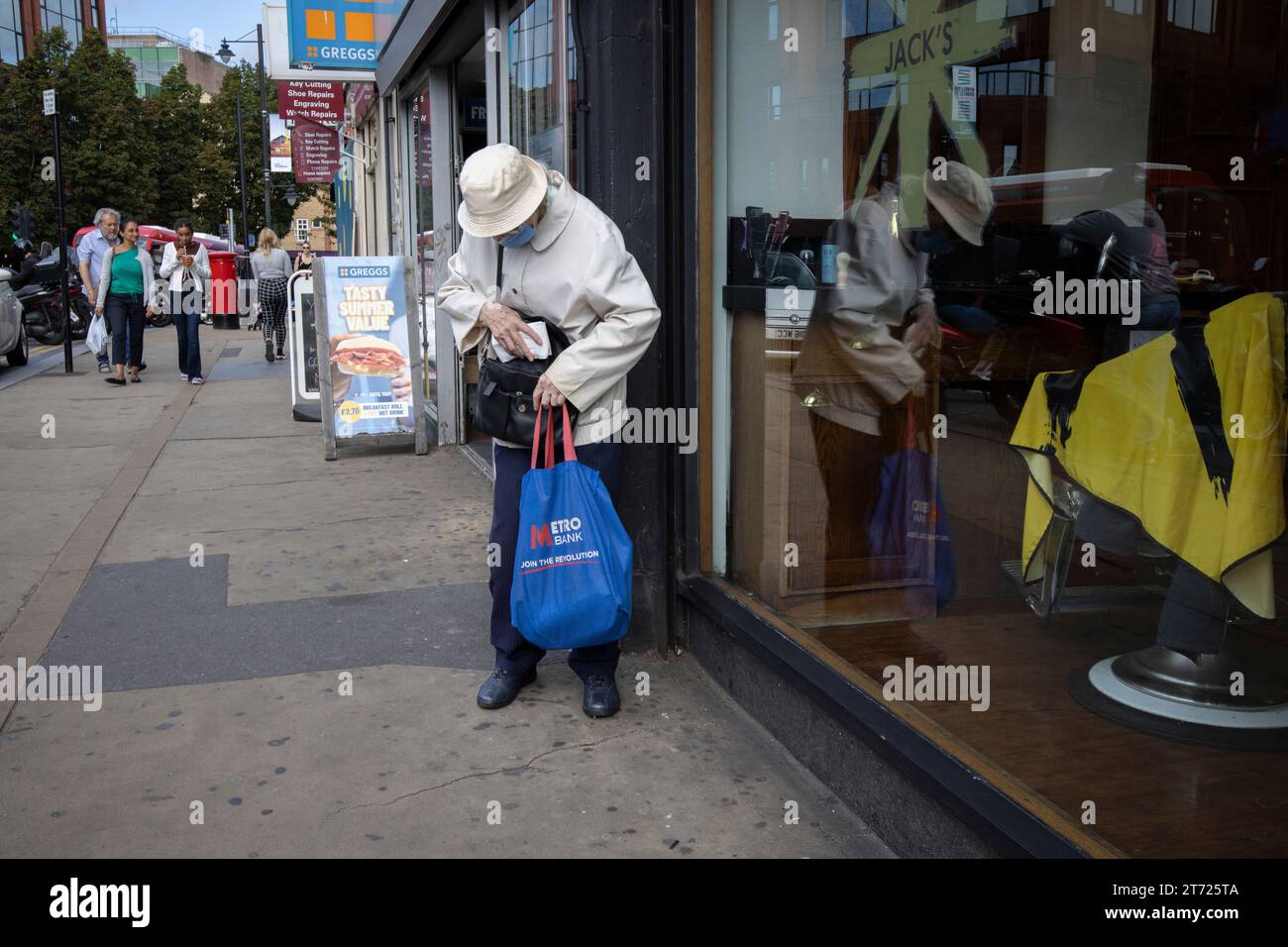 Elderly lady holds her Metro Bank tote bag whilst looking inside her ...