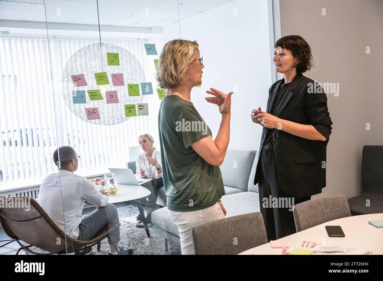 Coworkers brainstorming on window in office Stock Photo - Alamy