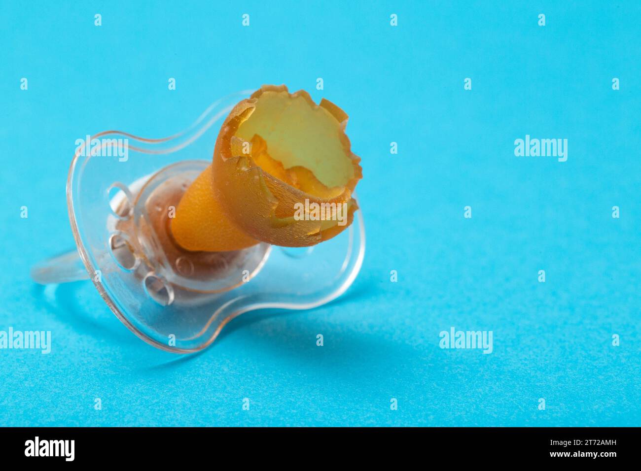 Torn and chewed baby silicone pacifier on a blue background, close-up ...
