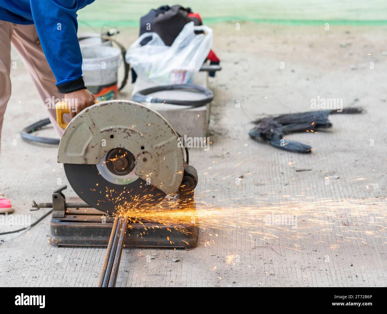 Worker cutting steel rod by circle cut machine at the construction site ...