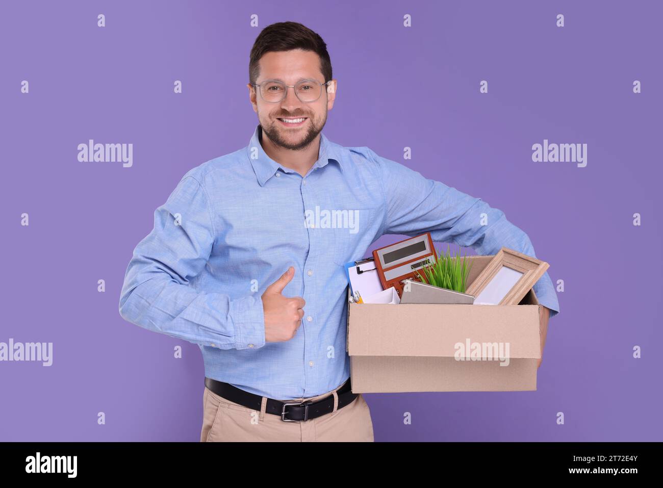 Happy unemployed man with box of personal office belongings showing ...