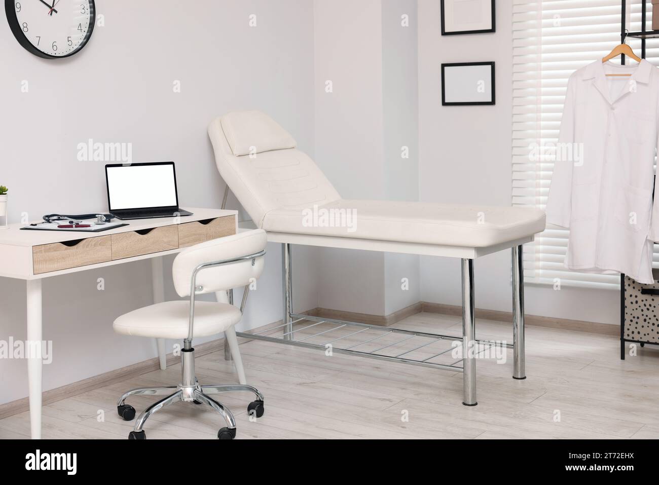 Modern medical office with doctor's workplace and examination table in ...