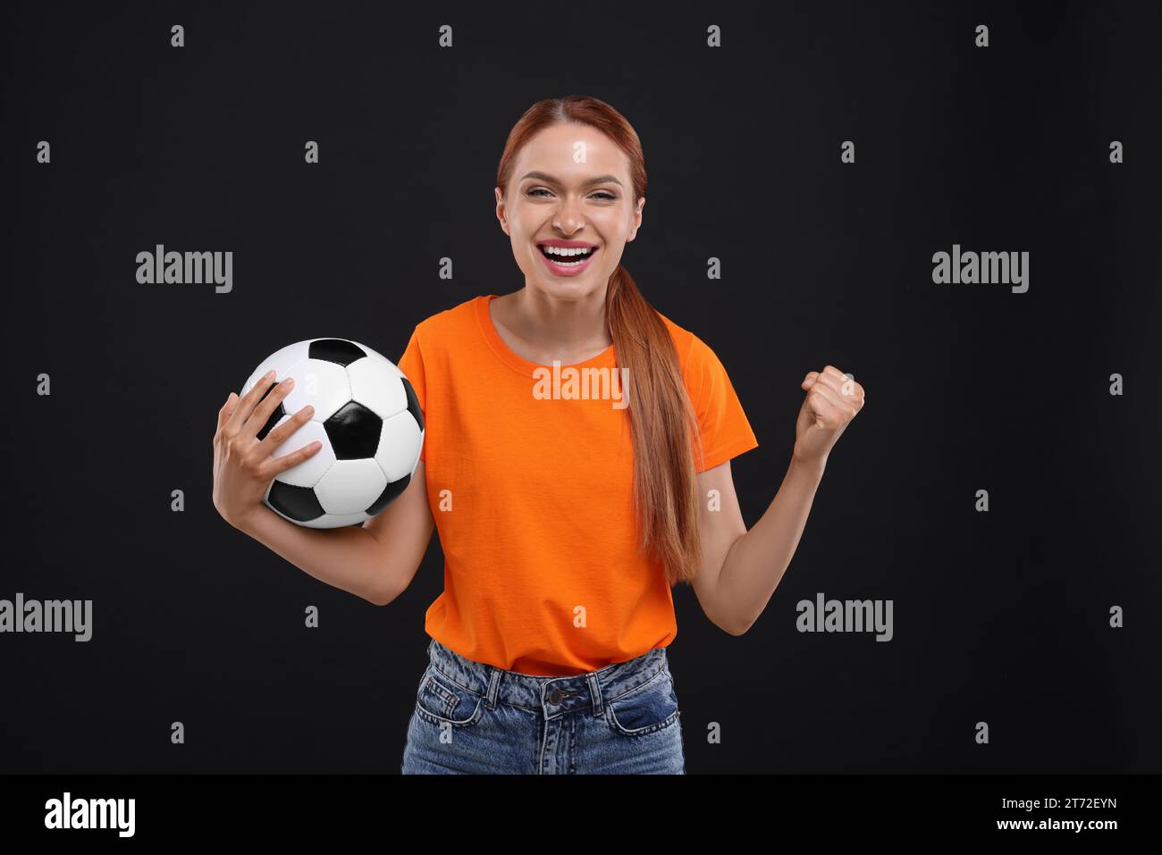 Happy fan with football ball on black background Stock Photo - Alamy