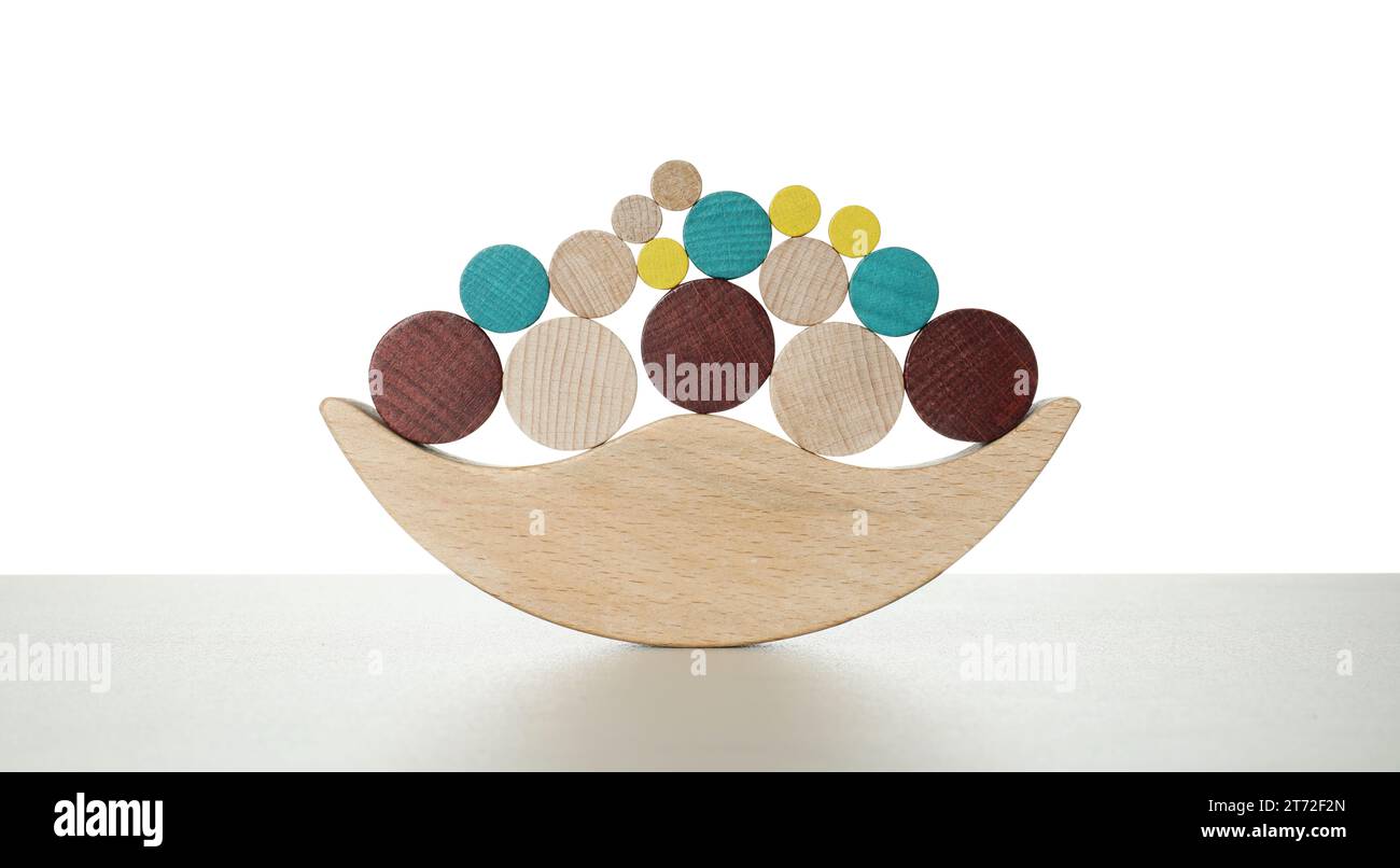 Wooden balance toy on light grey table against white background ...