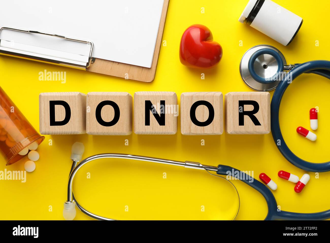 Flat lay composition with wooden cubes with word Donor on yellow ...