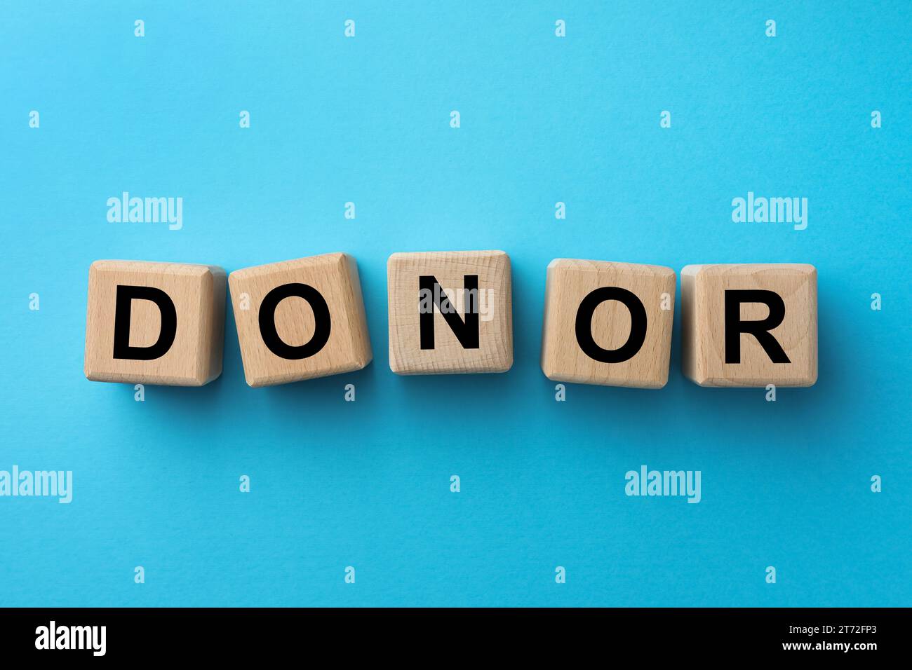 Wooden cubes with word Donor on light blue background, flay lay Stock ...