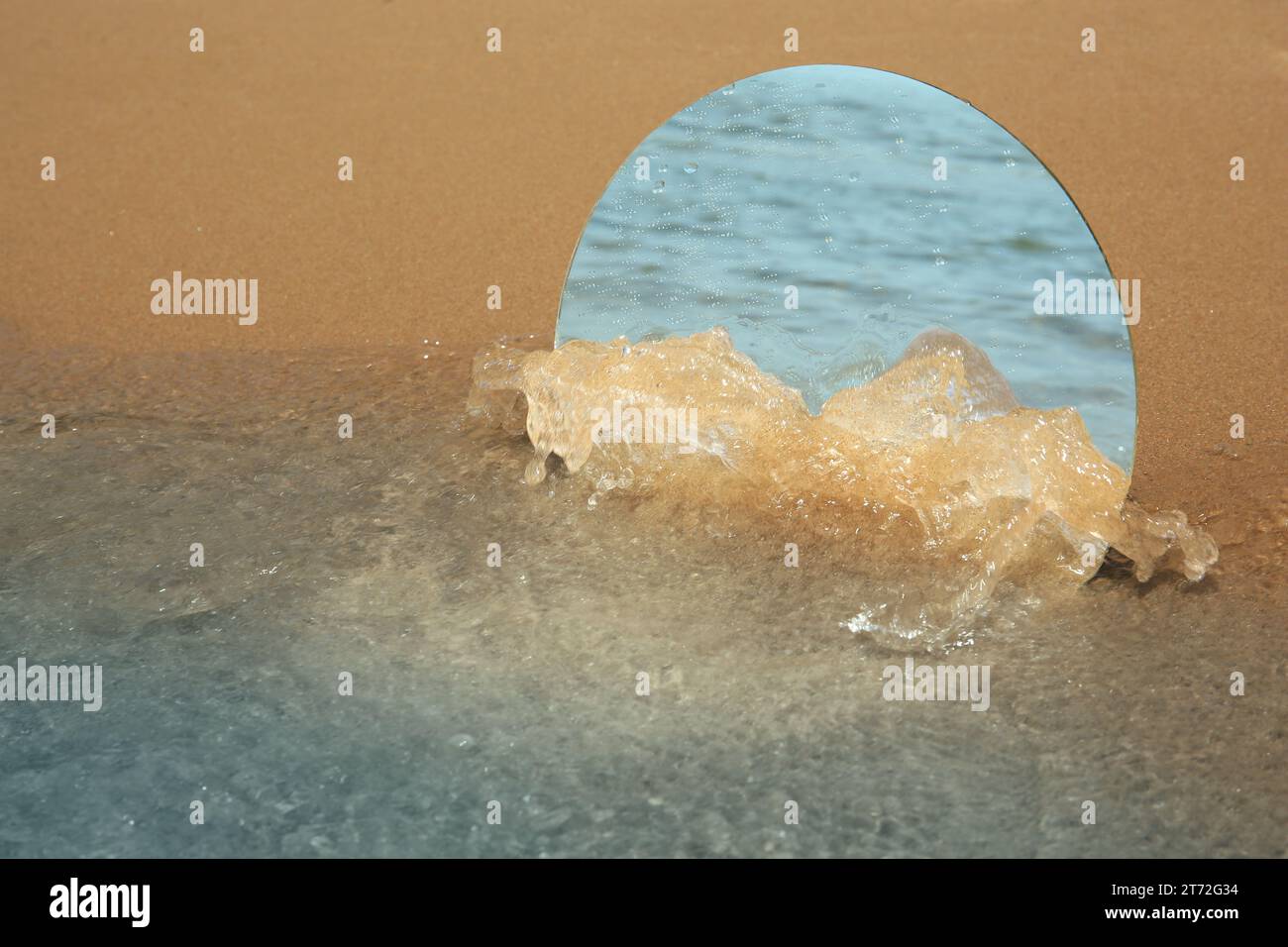 Round mirror reflecting sea on sandy beach Stock Photo - Alamy