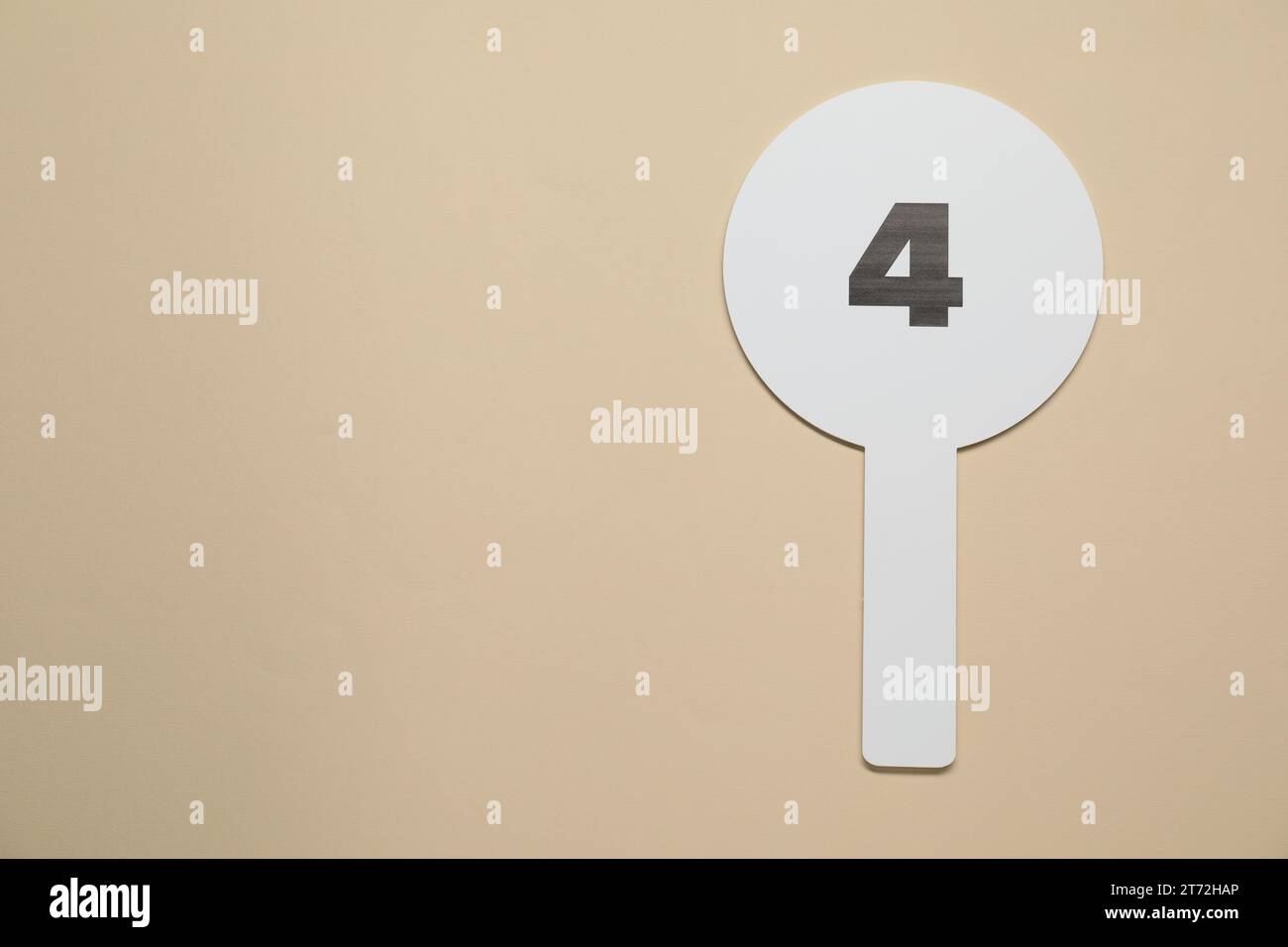Auction paddle with number 4 on beige background, top view. Space for ...