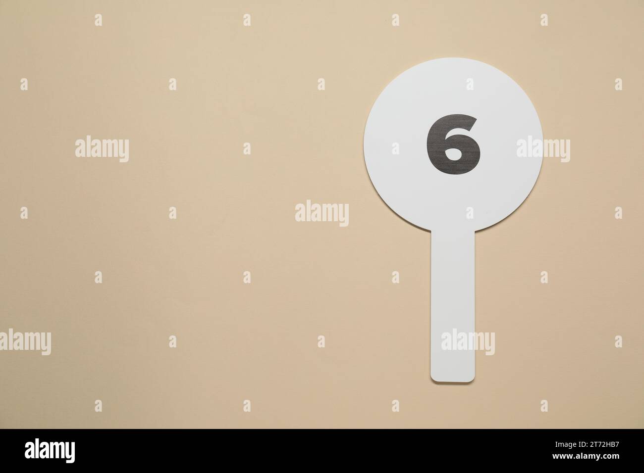 Auction paddle with number 6 on beige background, top view. Space for ...
