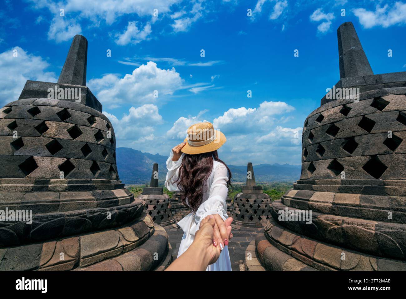 Women tourists holding man's hand and leading him to Borobudur Temple ...