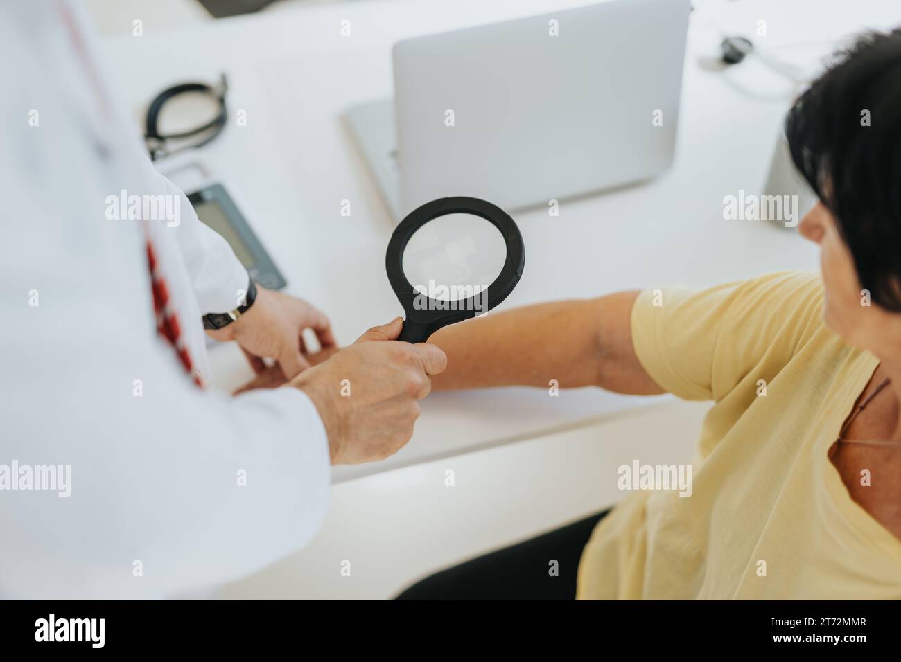 Cropped photo of doctor checking patient skin using magnifying glass ...
